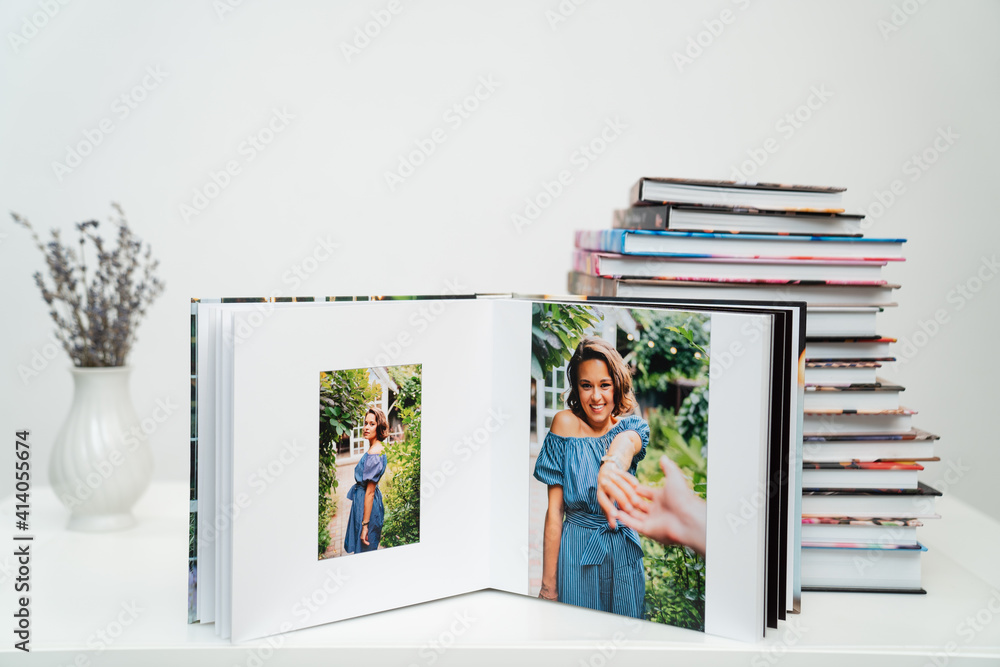 stack of books. open photobook from photo shoots of a beautiful happy ...