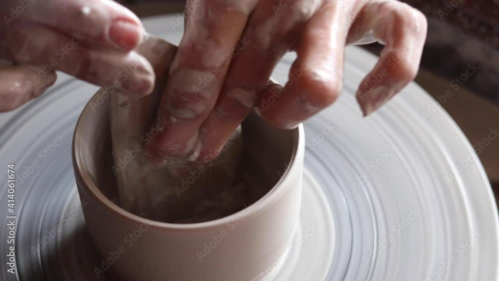 close up hand modeling pottery on a potter wheel in a cozy home ...