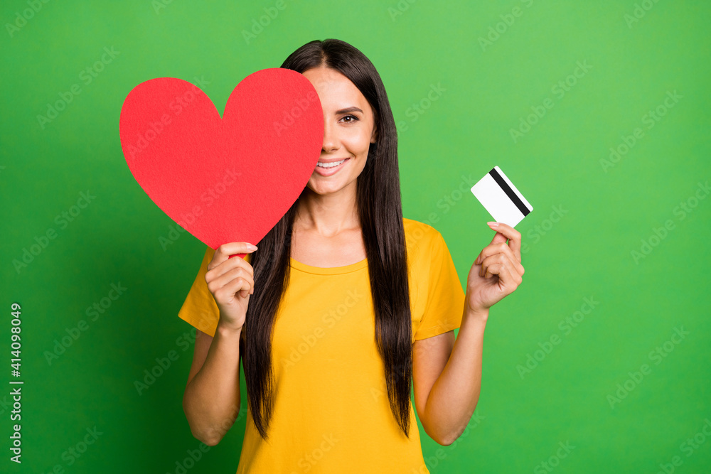 Photo of charming woman hold red heart debit card cover face wear ...