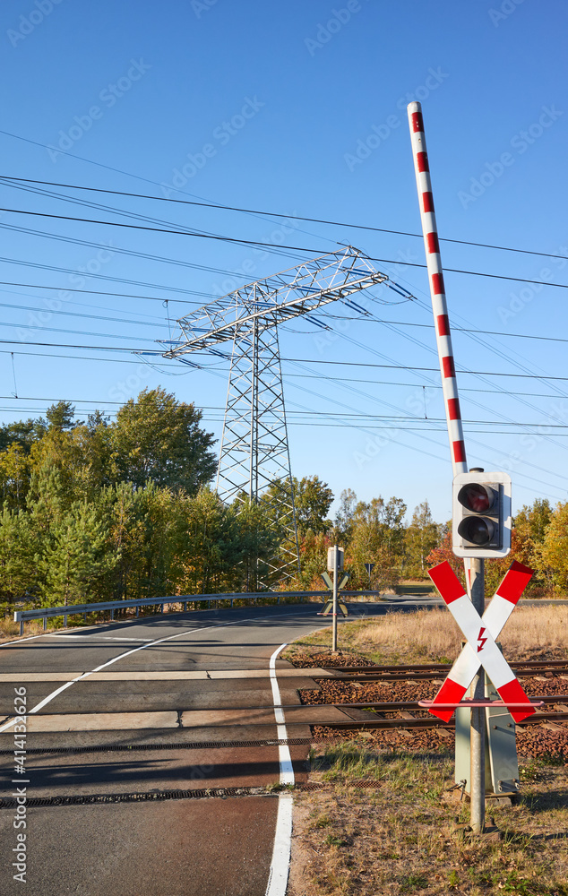 Rail crossing with high voltage power transmission line in background ...
