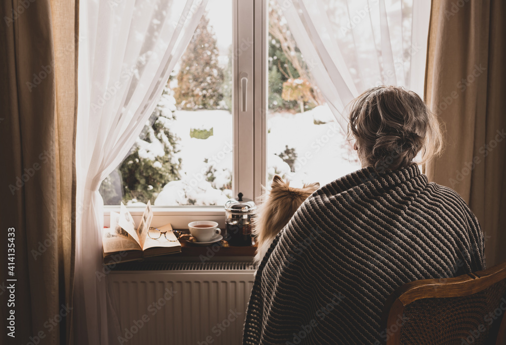Old retired woman (senior) by the home window - retirement concept ...