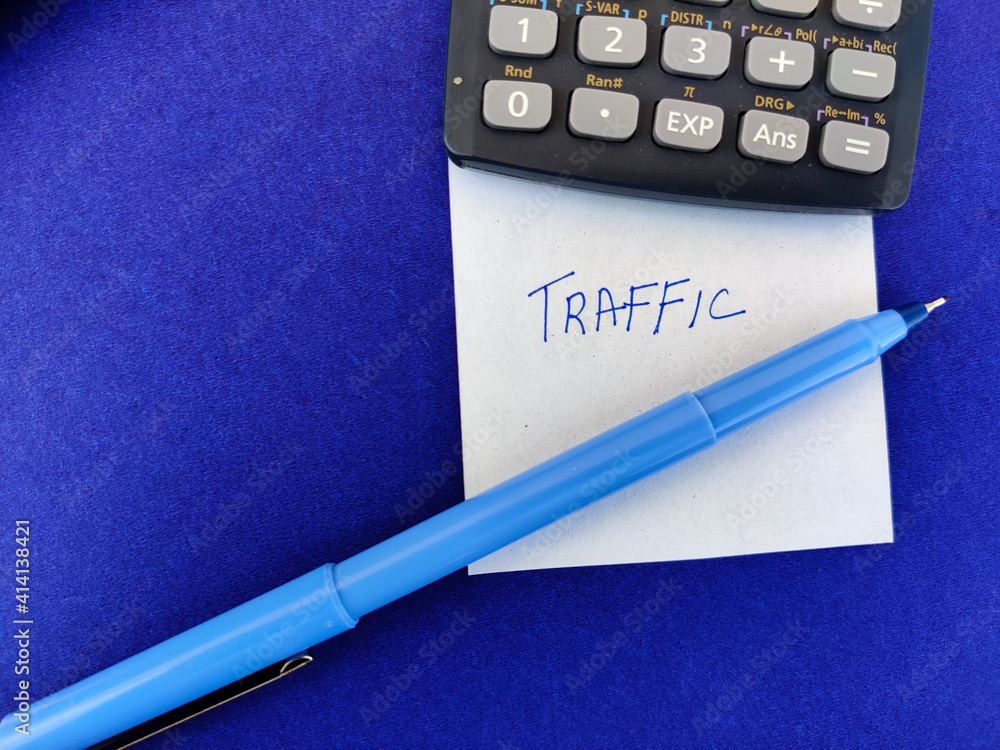 A White sticky note with text TRAFFIC kept under scientific calculator ...
