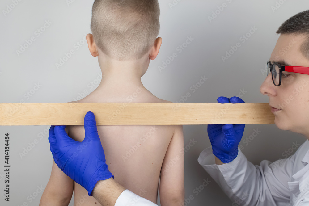 A little boy at the doctor's appointment with back pain. Treatment of ...
