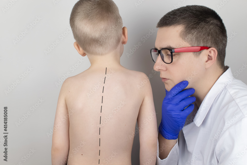 A little boy at the doctor's appointment with back pain. Treatment of ...