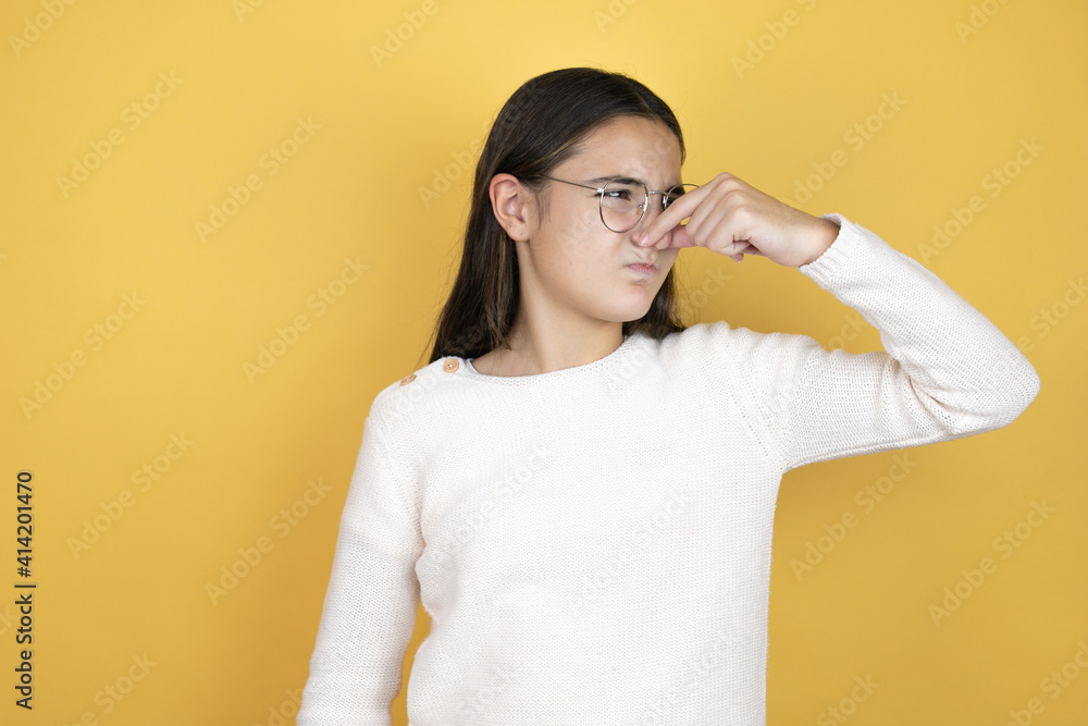 Beautiful child girl wearing casual clothes smelling something stinky ...