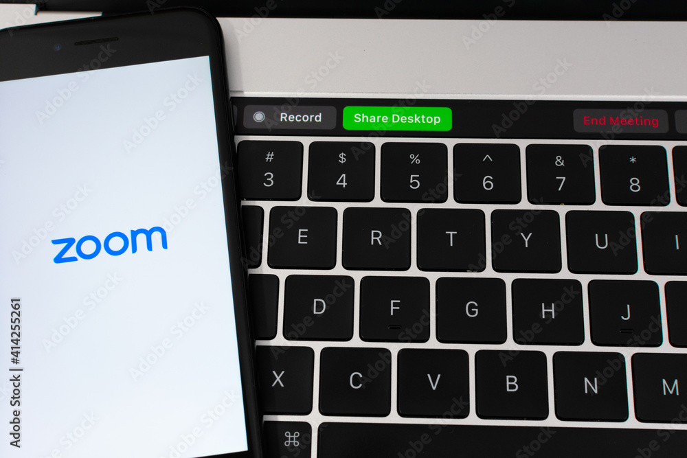 Zoom video conferencing mobile app is opened on a smartphone. MacBook ...