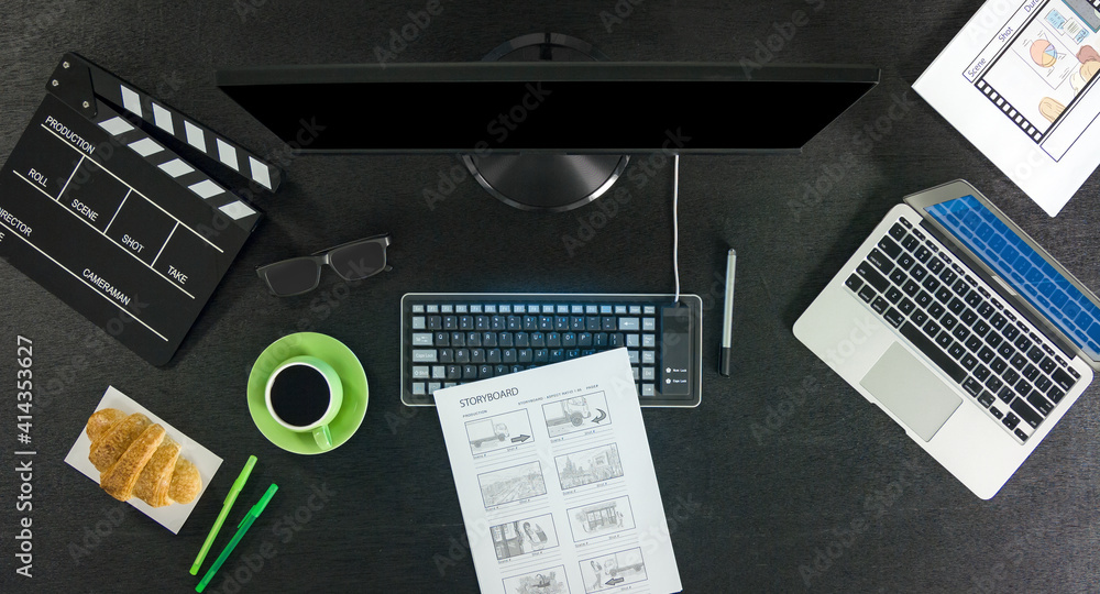 Top view of writer's workplace - big pc monitor and storyboard sheets ...