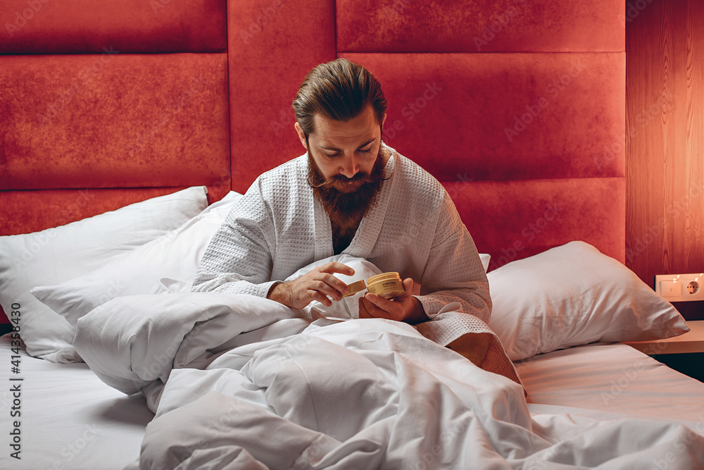 Busy, focused attractive man with a long mustache and beard sitting on ...