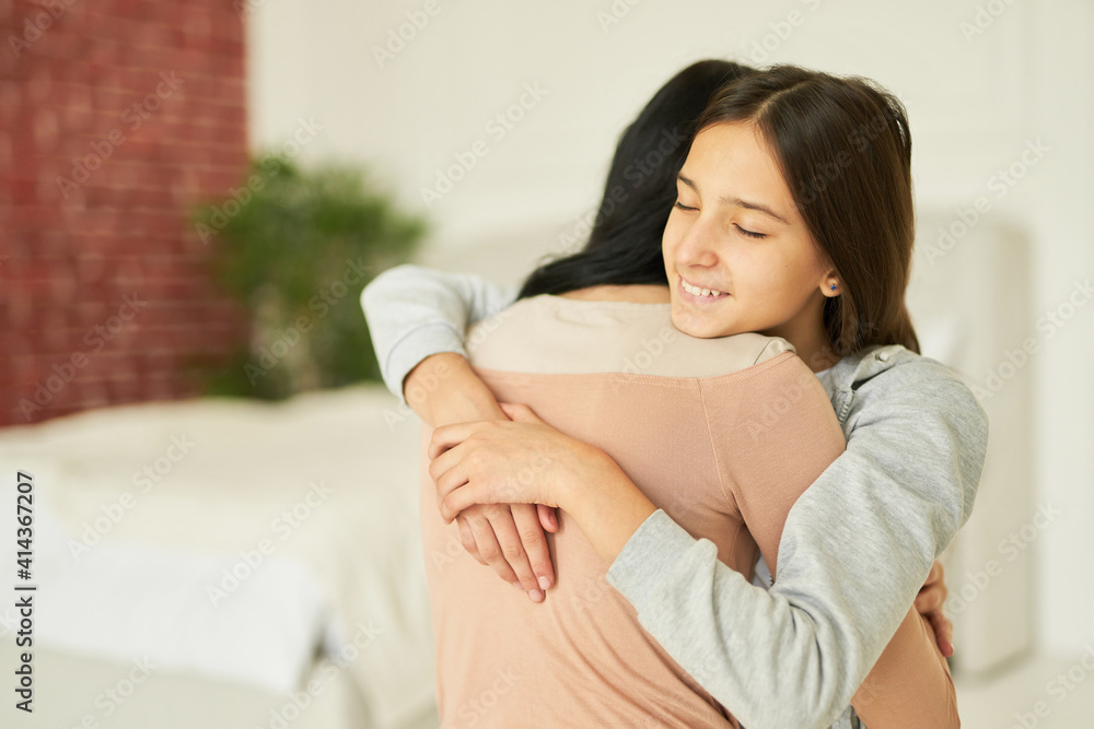 Hug your Mom. Cute teenage girl hugging her mother, looking ...