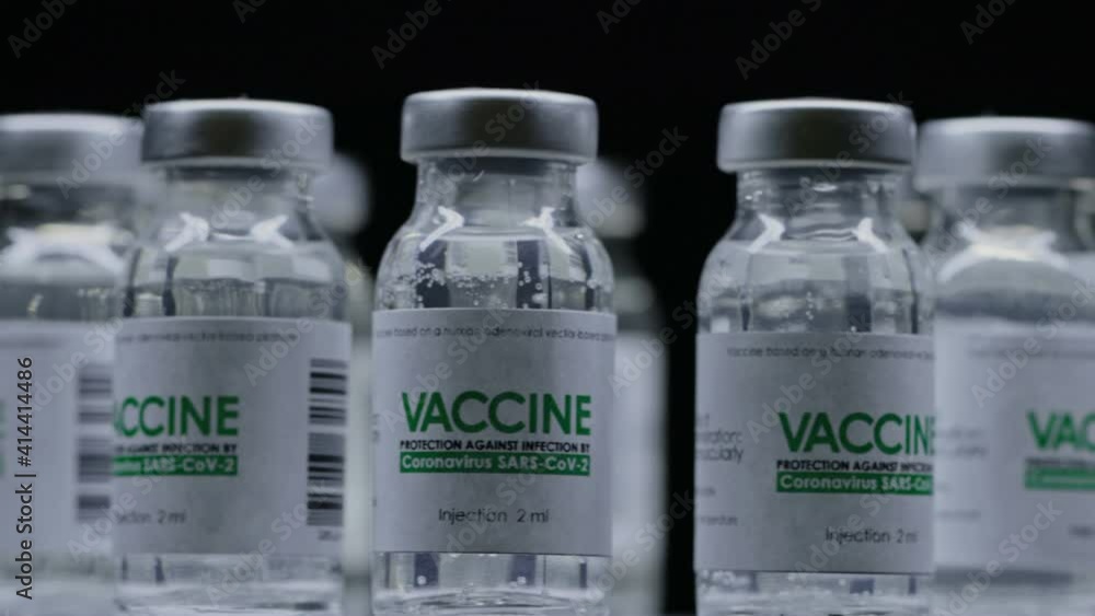 Vials of vaccine for COVID-19 coronavirus cure are slowly rotated in ...