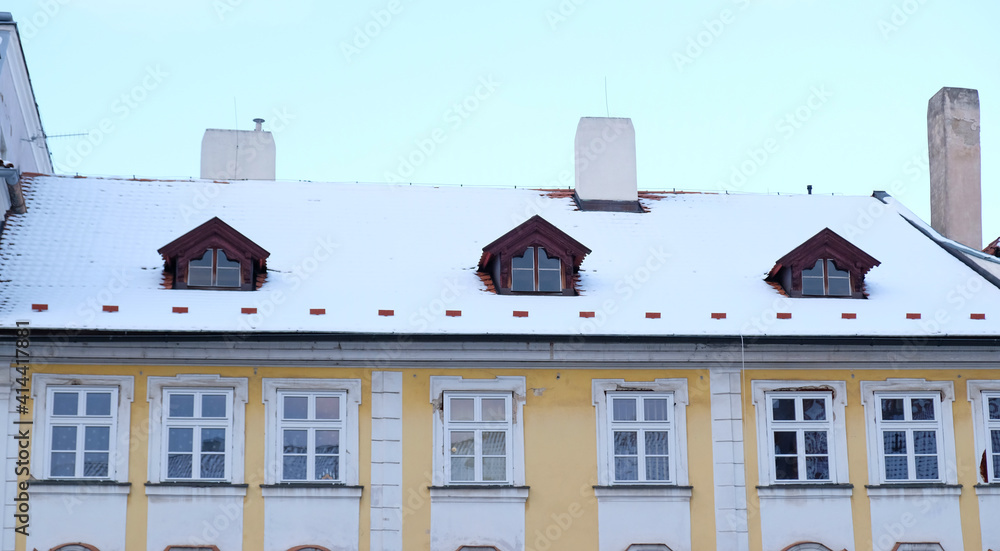 Exterior of apartments with gable roofs and dormers covered with snow ...