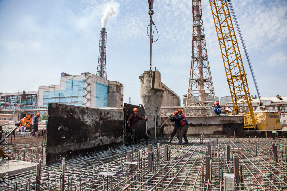 Old phosphate fertilizer plant in modernization. Workers with cement ...