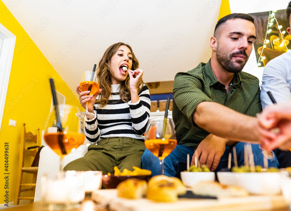 Young friends having fun at home aperitif with spritz cocktail and ...