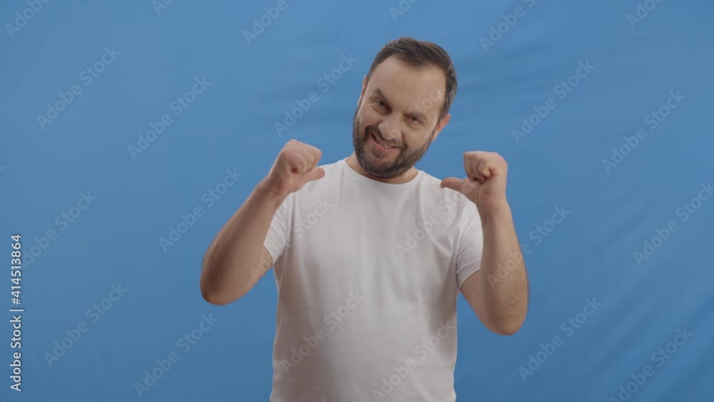 A self-righteous happy young man in front of the blue background ...