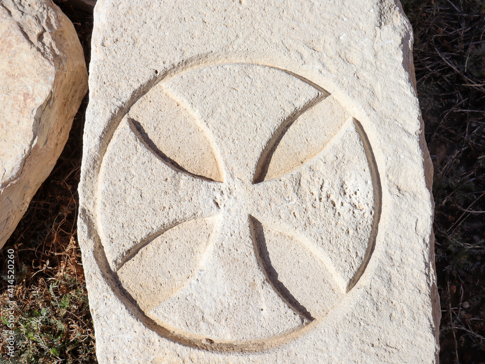 Ancient symbol of the cross in a circle, carved in stone. Ruins of the ...