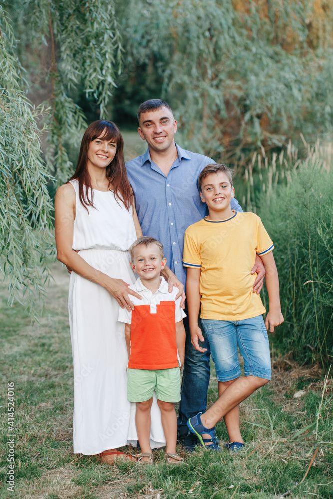 Beautiful happy Caucasian family of four people in park on summer day ...