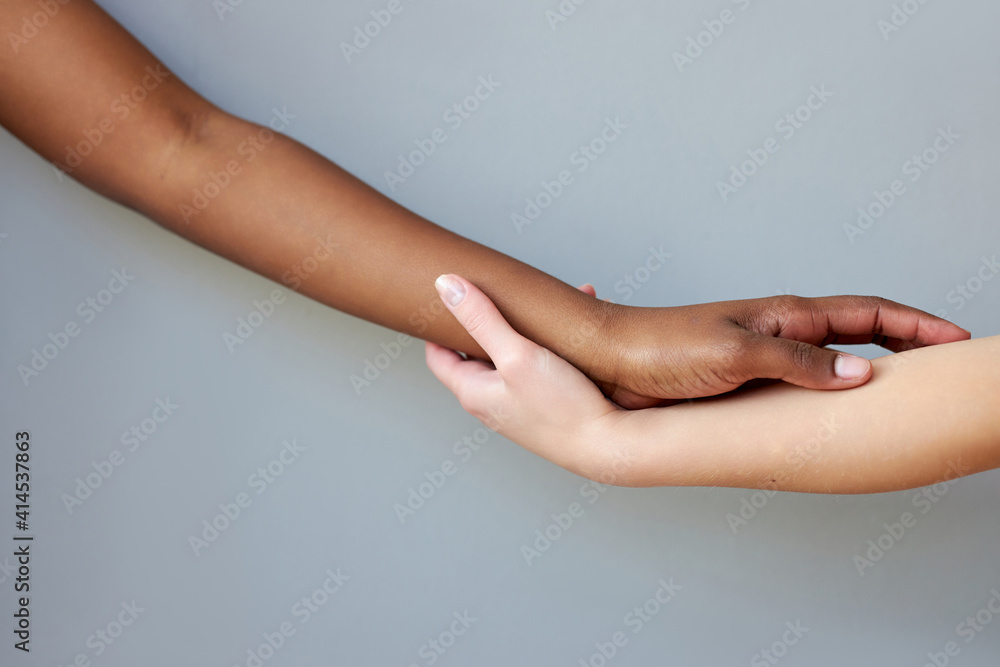 black and white female hands touching each other. Symbol of ...