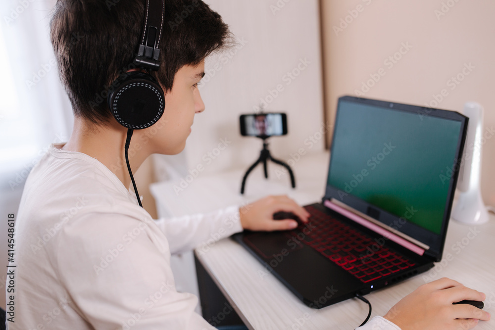 Teenage boy playing game on his pc computer in white room. Gamer ...