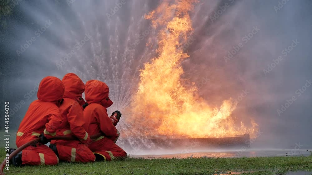 Firefighter fighting with fire flame protection property. Fireman wear ...