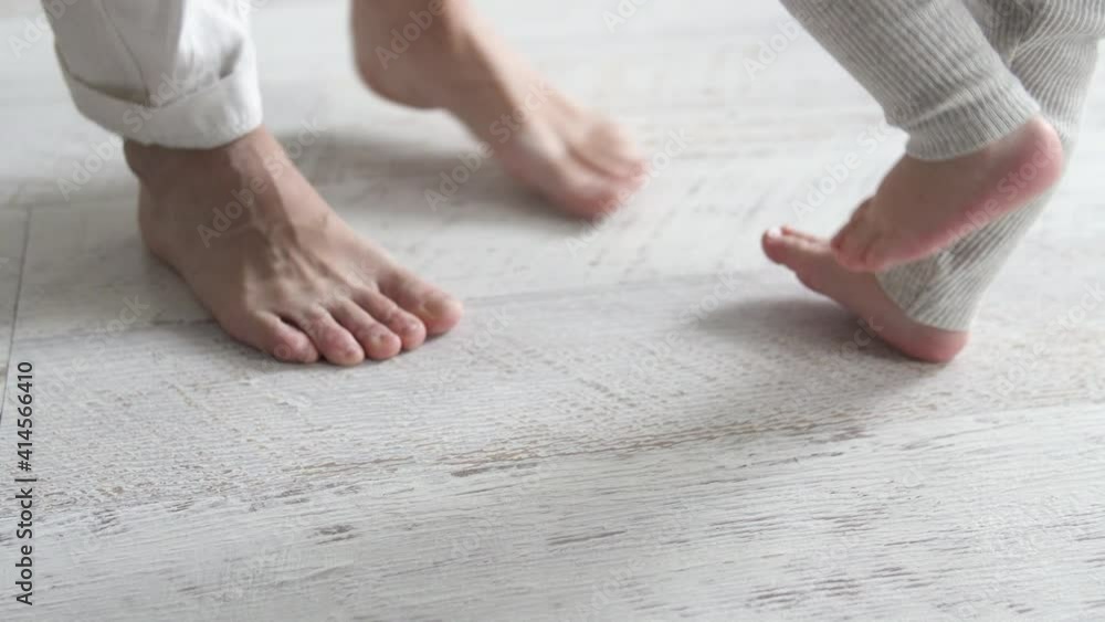 Mom and child playing with legs, stomping trying to step to each other ...