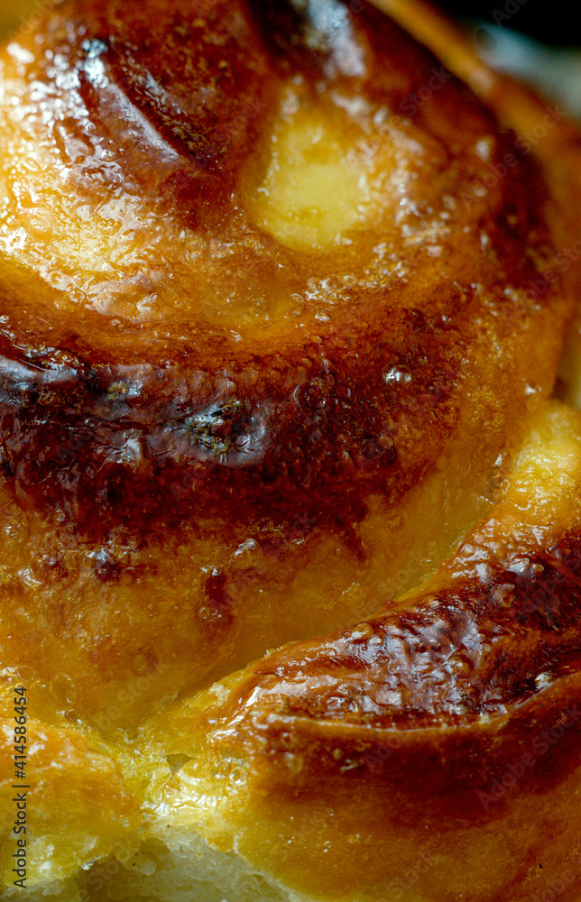 Macro photo of a sticky, well done sweet cheese roll. Baked food ...