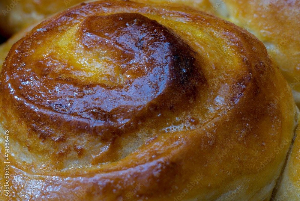 Macro photo of a sticky, well done sweet cheese roll. Baked food ...