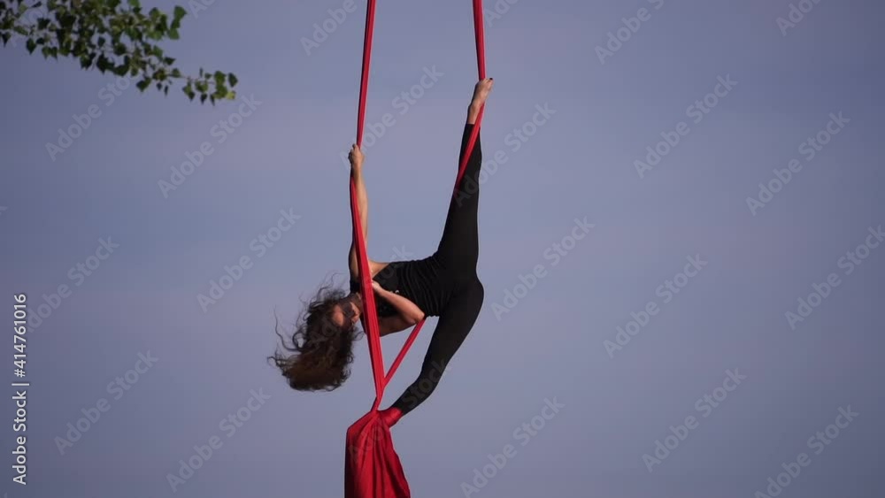 Stockvideon Female acrobat showing her flexibility and splits with red ...