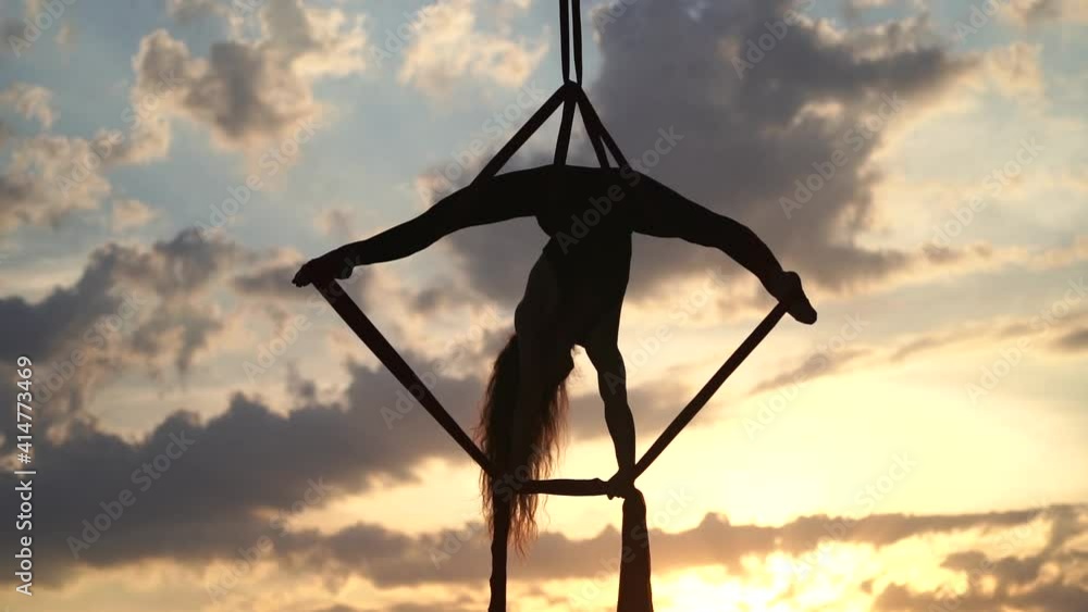 Silhouette of Female circus artist showing her flexibility and splits ...