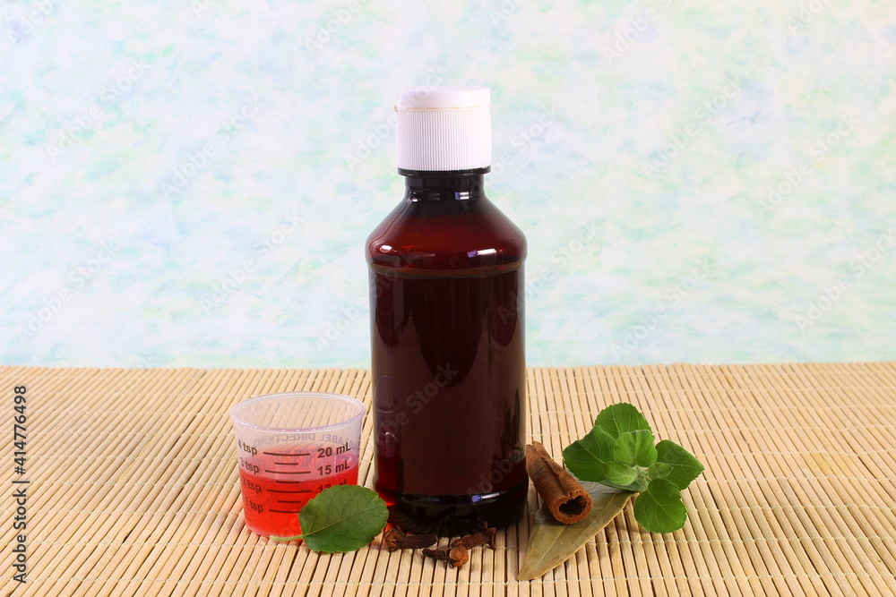 herbal ayurvedic cough syrup or expectorant bottle with measure cup ...