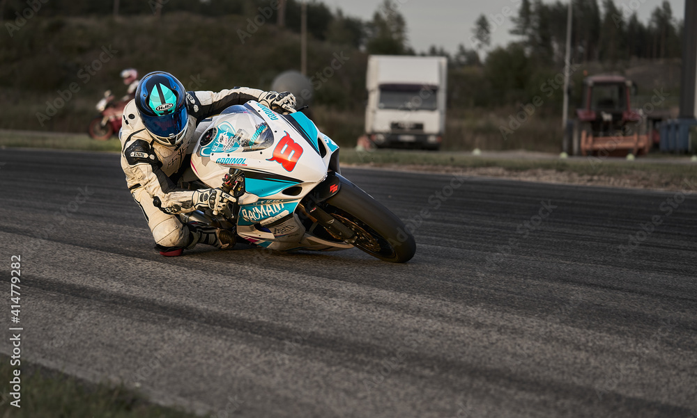 Motorcyclist at sport bike rides by empty asphalt road. sport bike ...