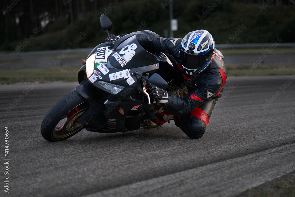 Motorcyclist at sport bike rides by empty asphalt road. sport bike ...
