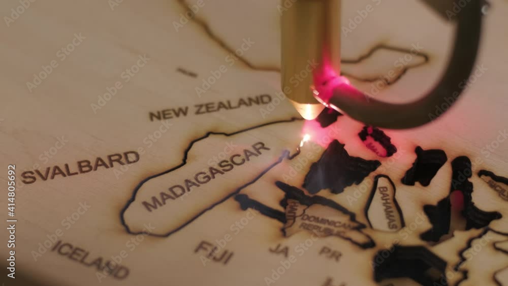 Cnc laser cutting machine cuts world map on wooden plank and plywood ...