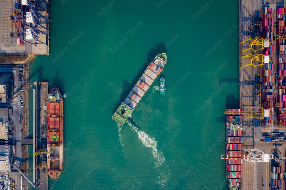 Aerial top view Tugboat pushing container ship in sea port Thailand ...