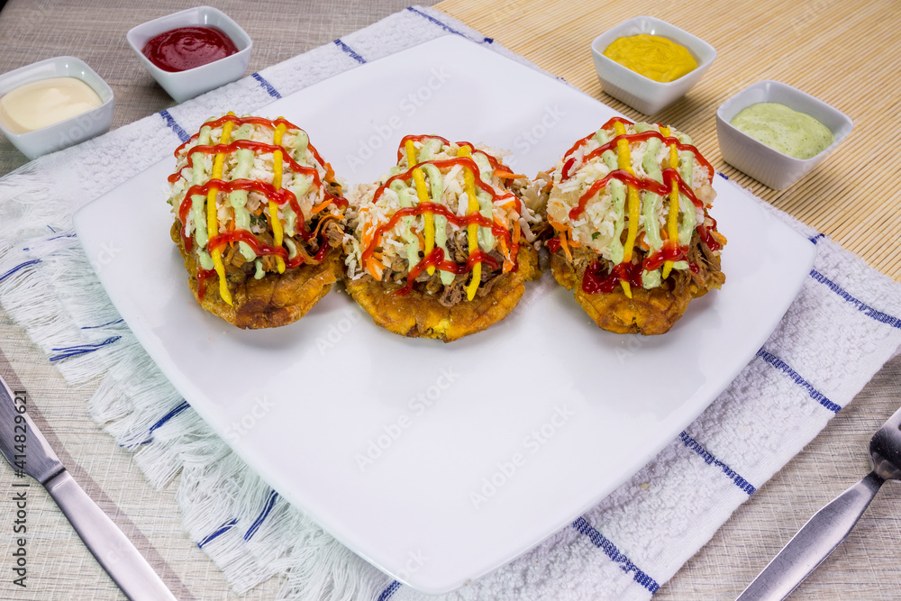 Plato de comida venezolana hecho de tostón con ensalada de col, queso ...