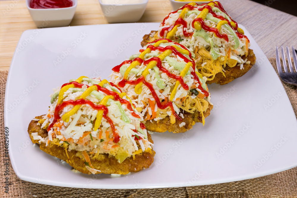 Plato de comida venezolana hecho de tostón con ensalada de col, queso ...