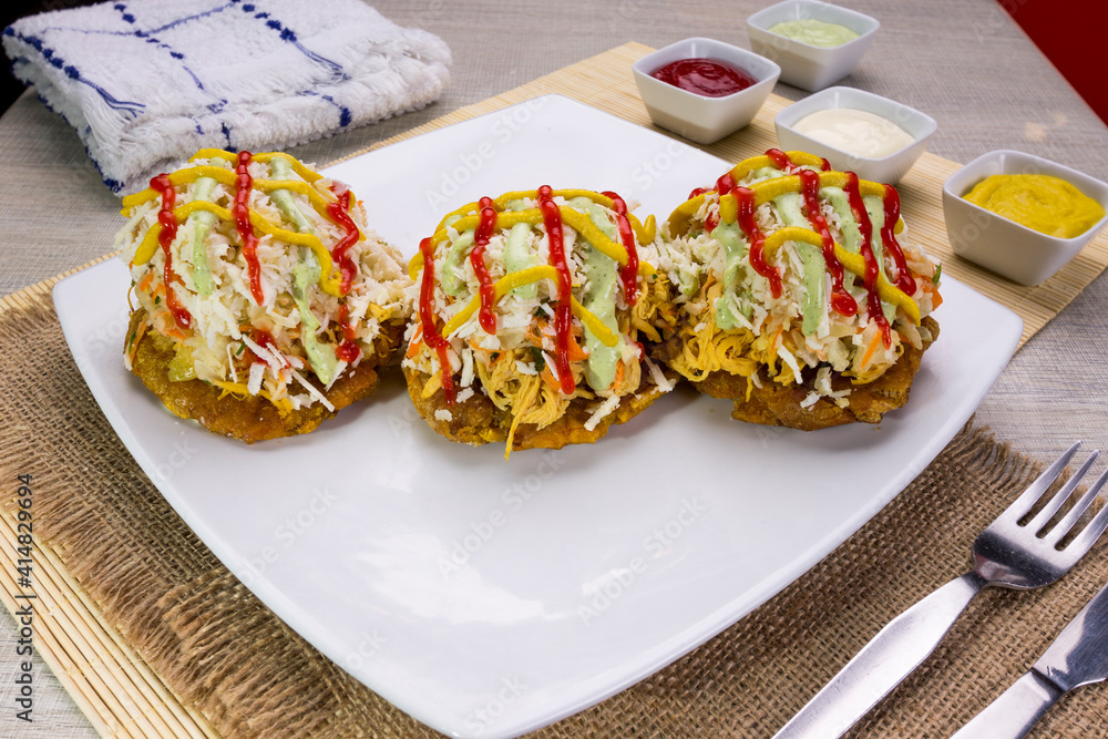 Plato de comida venezolana hecho de tostón con ensalada de col, queso ...