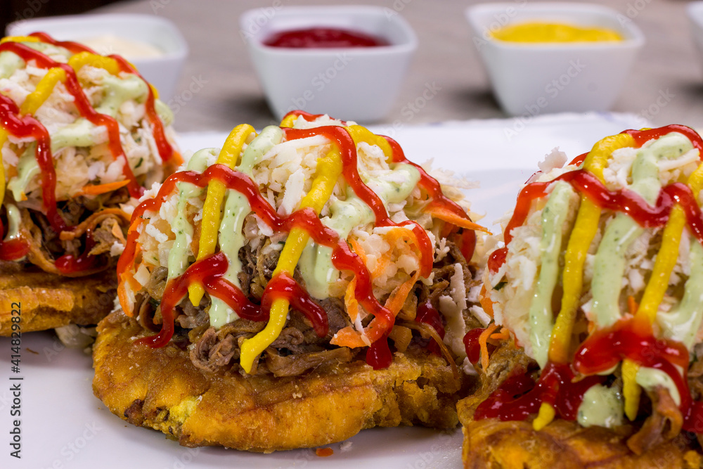Plato de comida venezolana hecho de tostón con ensalada de col, queso ...