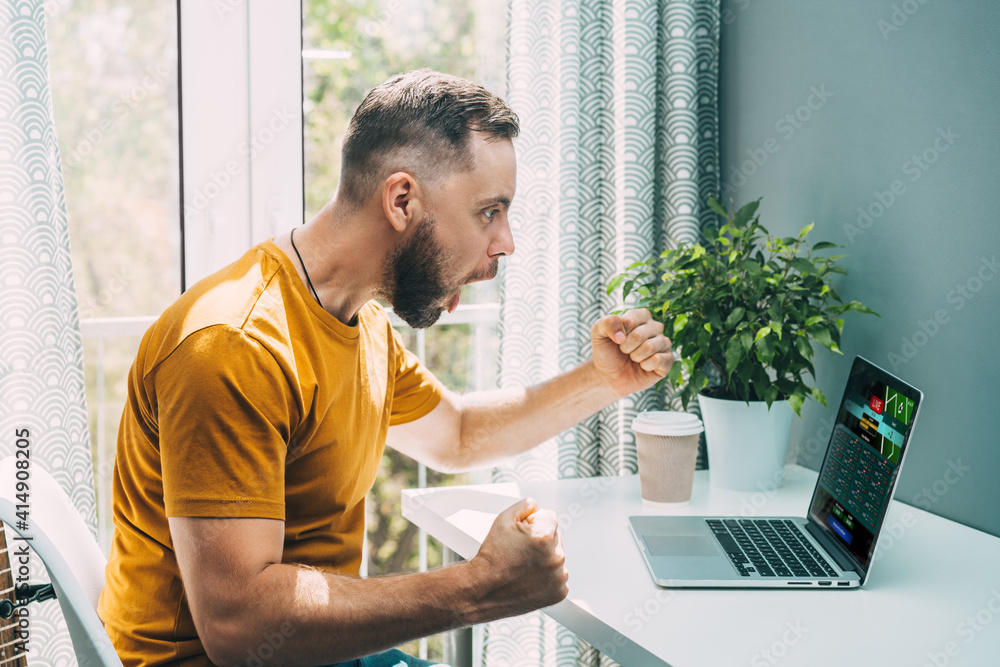 Football fan watching play live broadcast on his laptop computer and ...