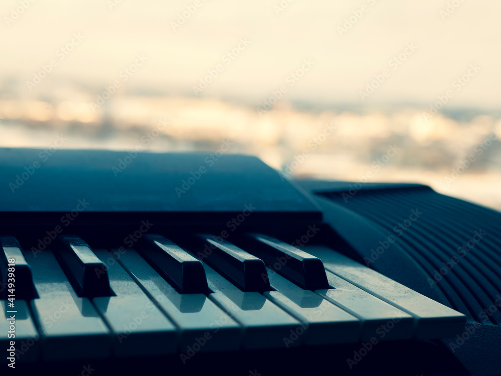 Piano keyboard with blurred background. Black and white keys are ...
