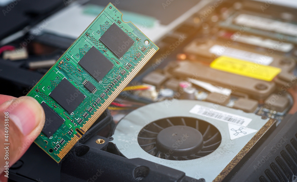 A man installed a new RAM memory chip into a laptop. Repair and upgrade ...
