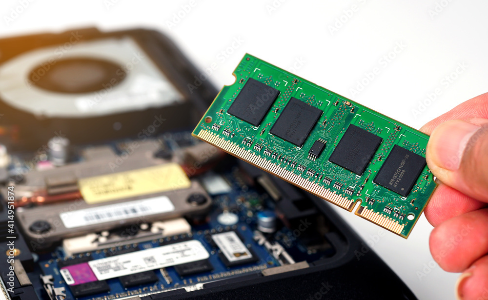 A man installed a new RAM memory chip into a laptop. Repair and upgrade ...