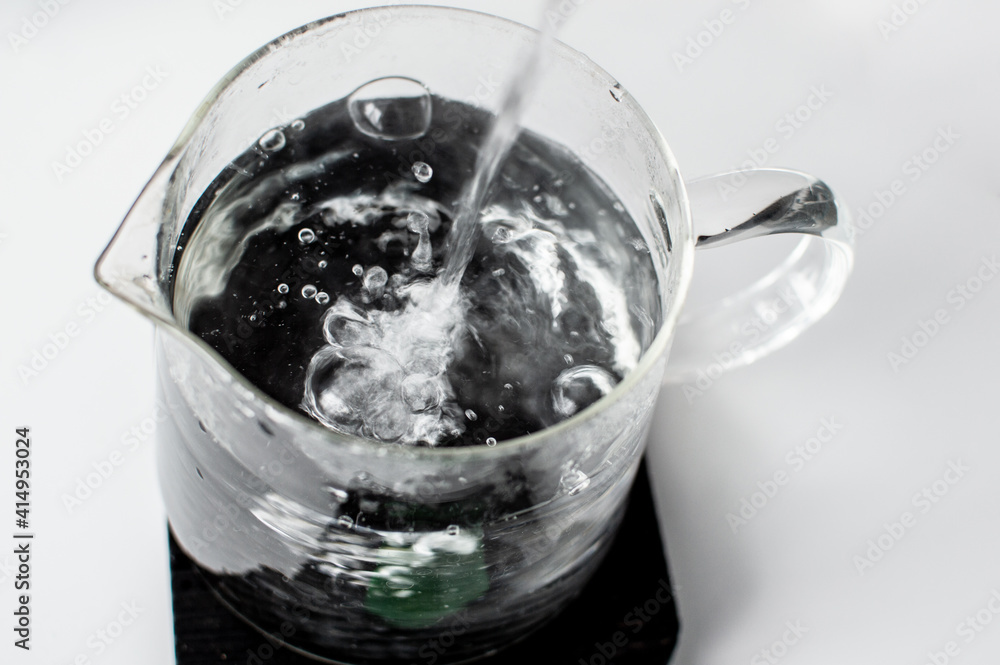 Bubbles in hot water boiling inside glass transparent teapot. Close up ...