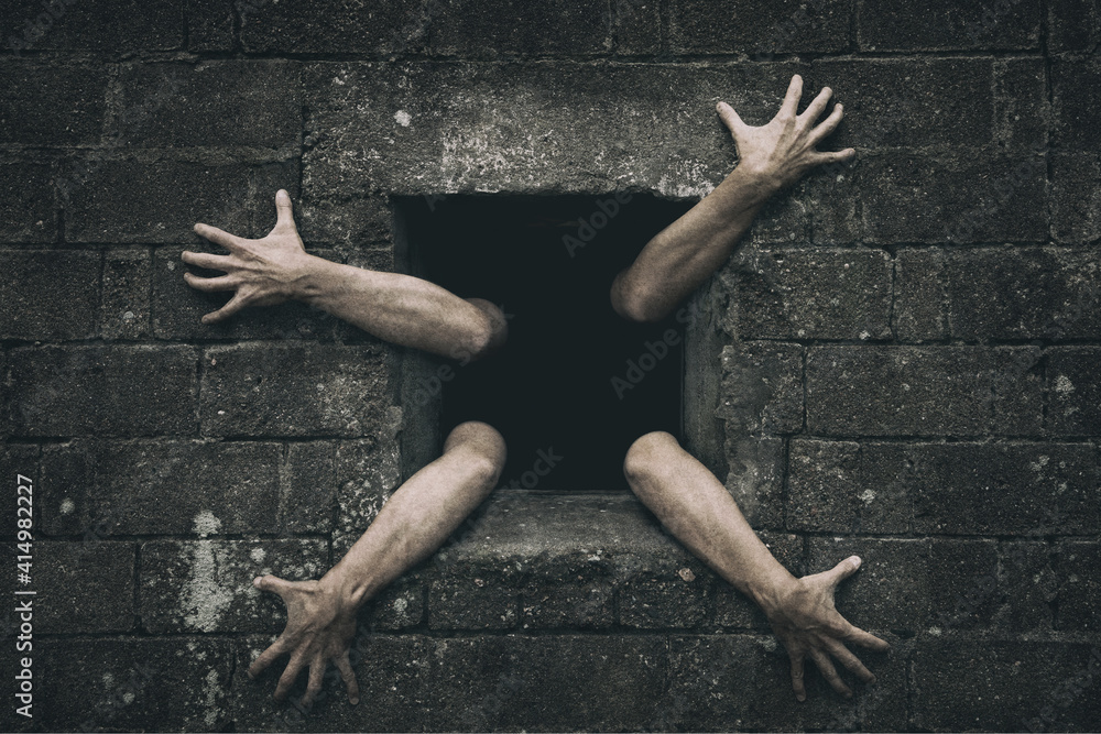 Fotka „Hands rising out from small window in concrete wall. Horror ...