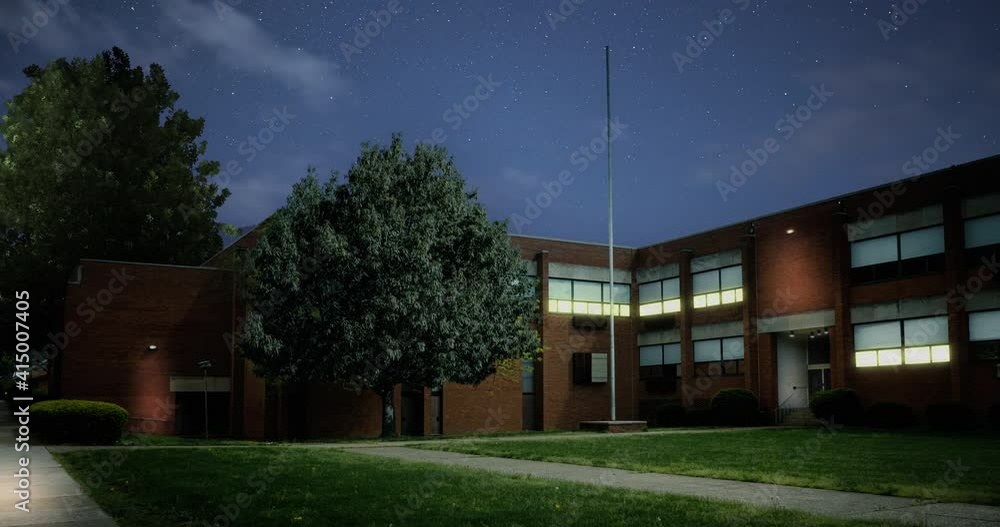 A night establishing shot of a typical small town two-story red brick ...