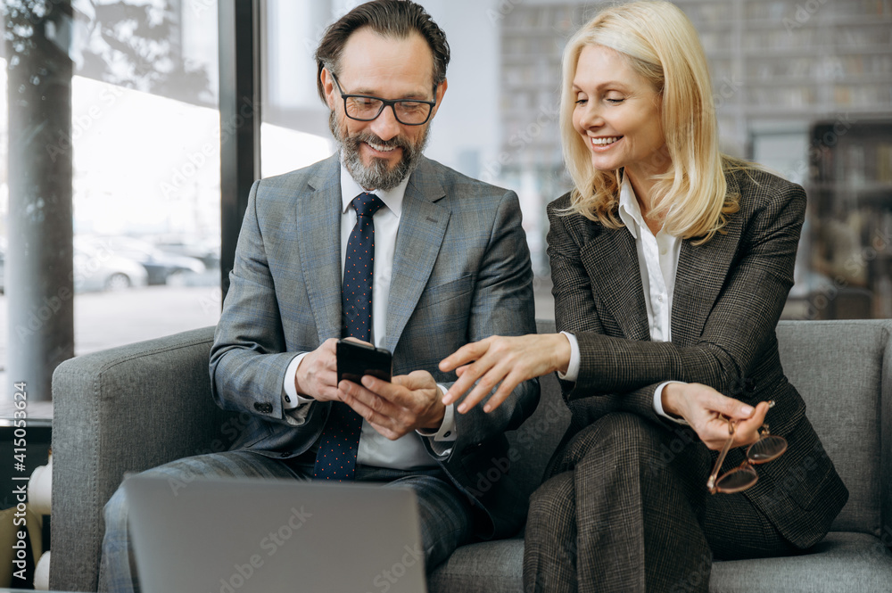 Happy friendly business partners using smartphone, browsing internet ...