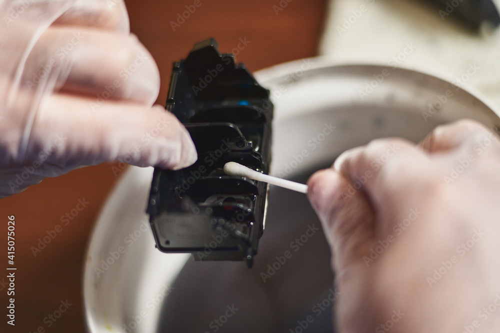 excess ink is removed from the printhead with a cotton swab. ink ...