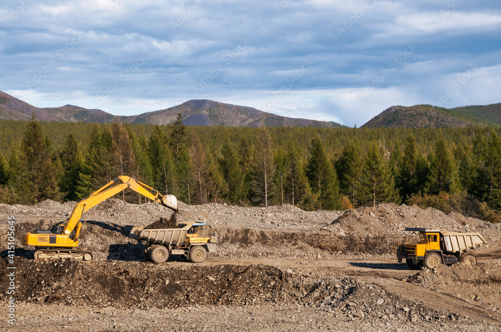 Excavator in the process of work in an industrial mountainous area ...