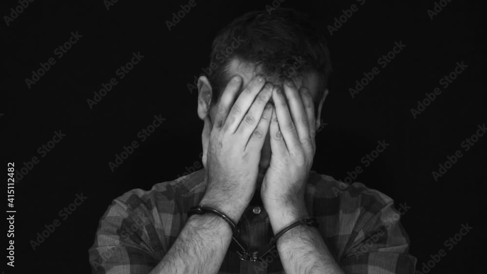 a man in handcuffs is crying. the criminal repents and cries. arrest of ...