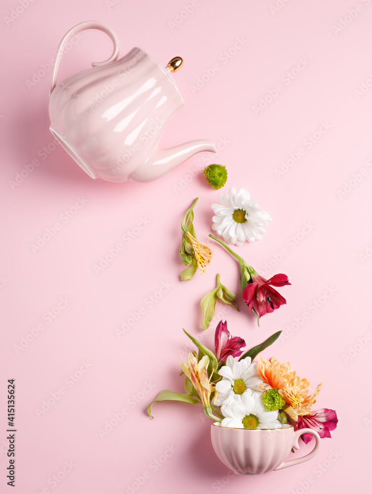 Creative layout with tea pot pouring fresh flowers and leaves into tea ...