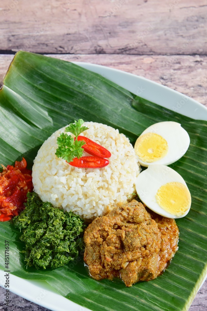 Indonesian cuisine Nasi Padang, rice with beef Rendang, salty anchovy ...